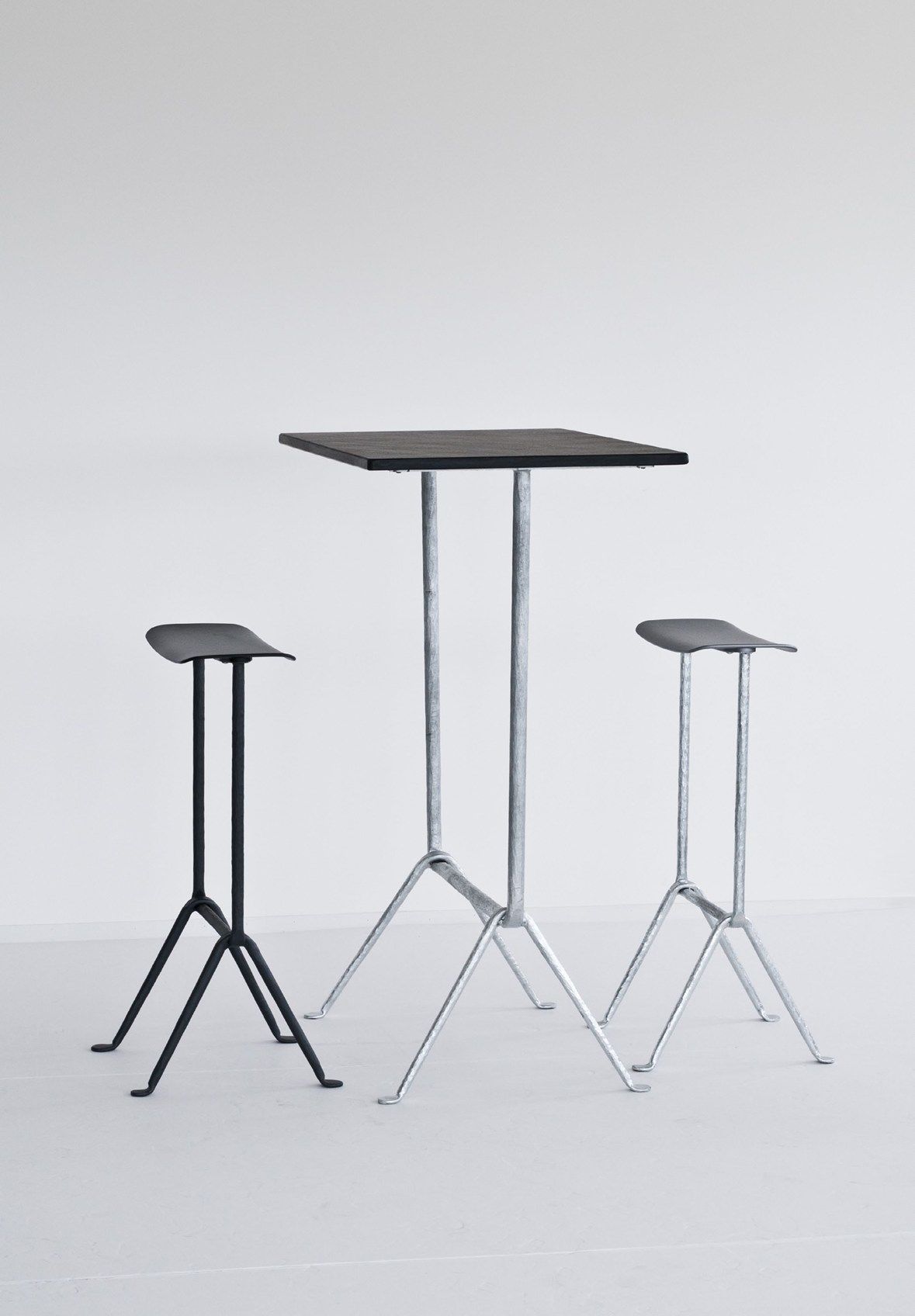 A system of forged iron legs supports surfaces of different sizes and ...