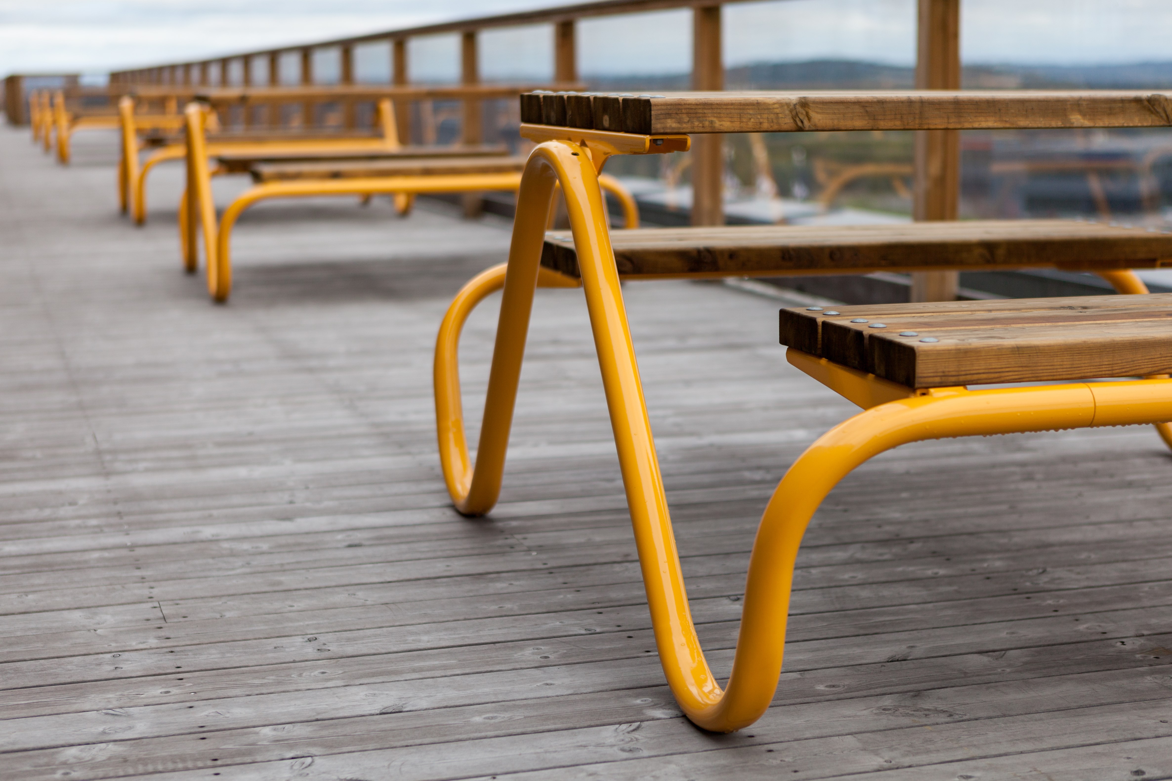 HVILAN | Table for public areas with integrated benches By VESTRE